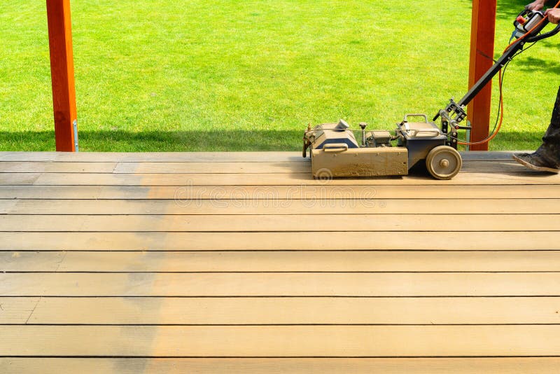 Worker Cleaning and Sanding a Wooden Deck with a Specialized Machine ...