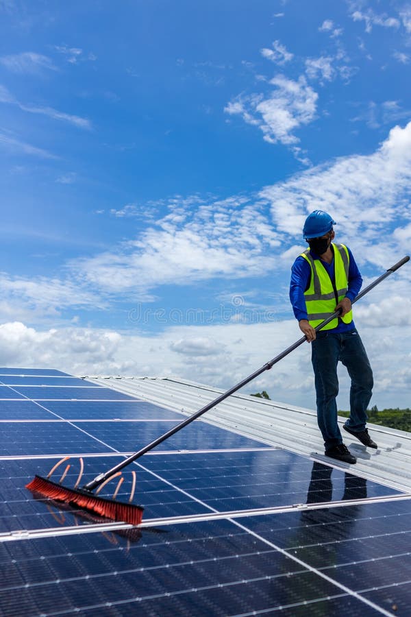 Worker Cleaning Solar Panels with Brush and Water. Worker Cleaning ...