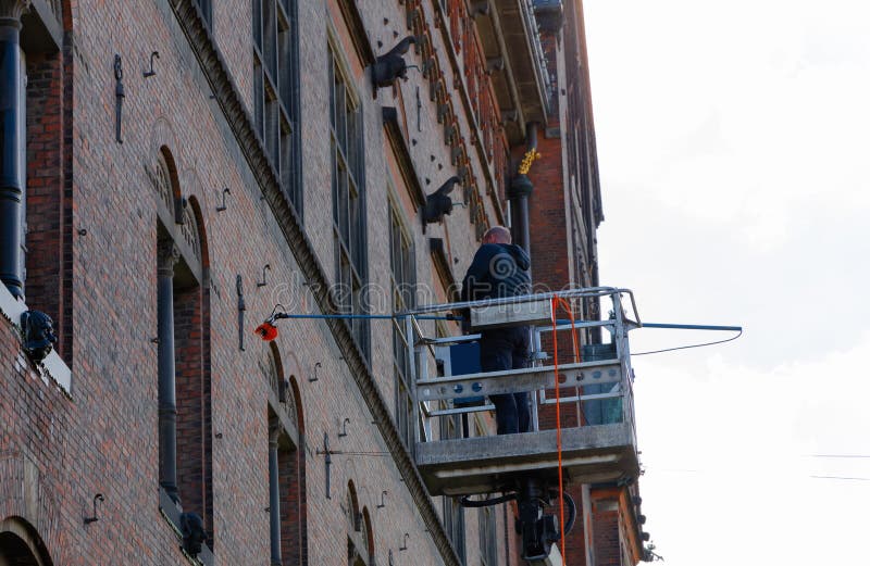 Worker Cleaning the Window of a Building at Heigt in Lifting Cradle ...