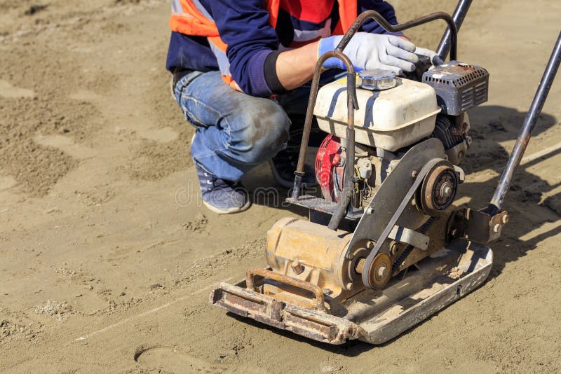 A Worker Cleans an Old Gasoline Compactor To Compact Sandy Soil ...
