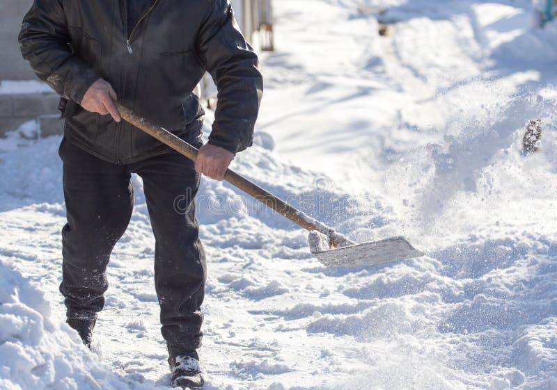Worker cleans snow shovel stock photo. Image of season - 91833780