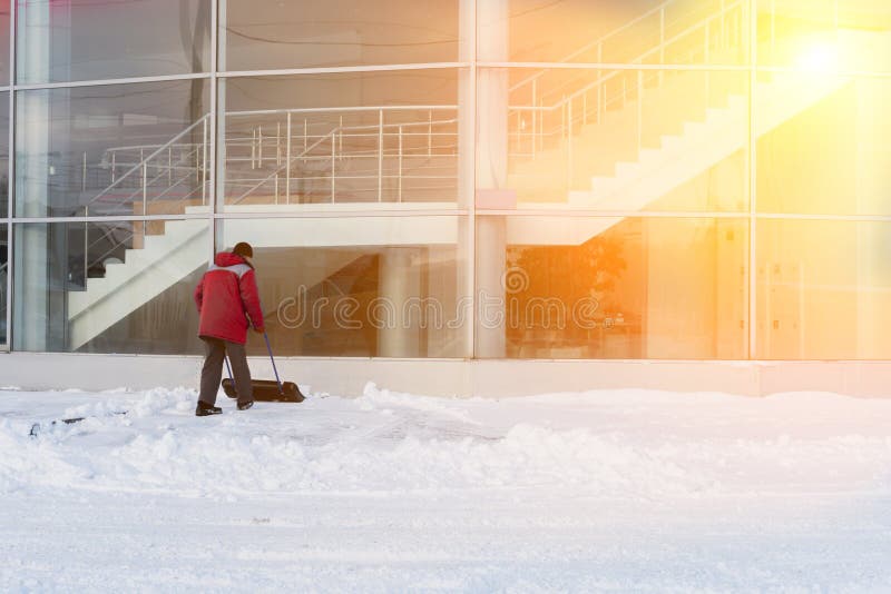 A Worker Clears Snow after a Snowstorm in Front of a Large Office ...