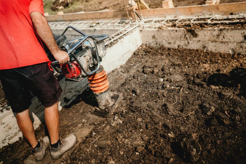 Worker Compacting Soil with Vibration Compaction Machine during ...