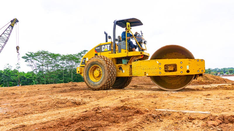 A Worker Compacts Soil Using a Vibration Roller Compactor at a Toll ...