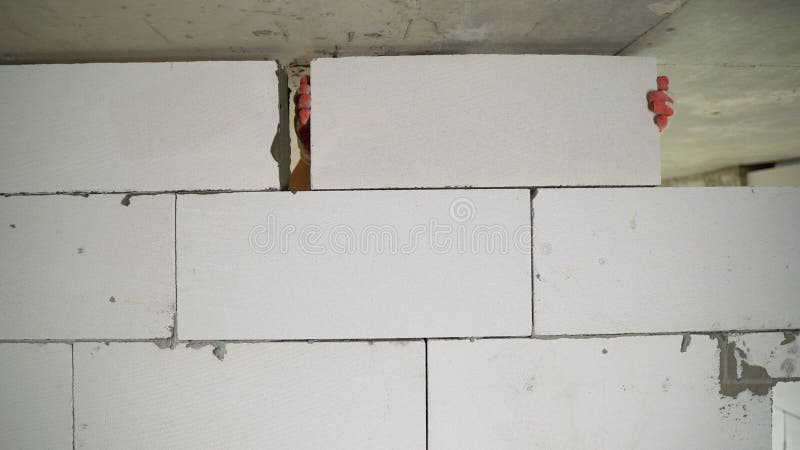 Worker at the Construction Site. Professional Builder Laying Blocks ...