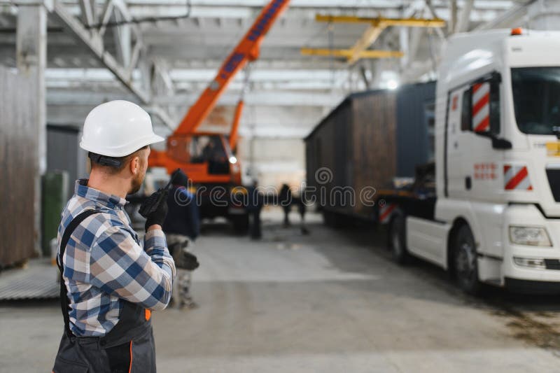 A Worker Controls the Process of Loading a Modular House Onto a Truck ...