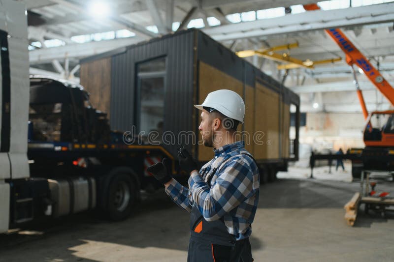A Worker Controls the Process of Loading a Modular House Onto a Truck ...
