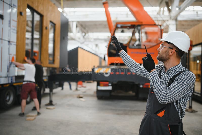 A Worker Controls the Process of Loading a Modular House Onto a Truck ...