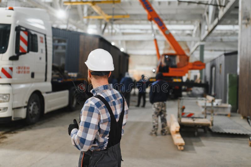 A Worker Controls the Process of Loading a Modular House Onto a Truck ...
