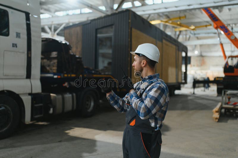 A Worker Controls the Process of Loading a Modular House Onto a Truck ...