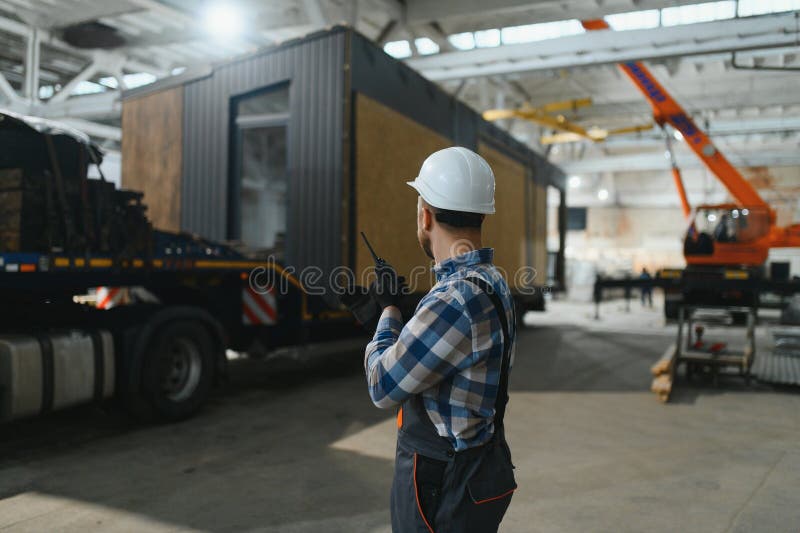 A Worker Controls the Process of Loading a Modular House Onto a Truck ...