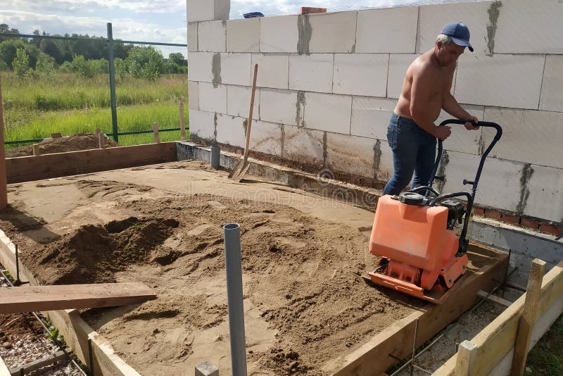 The Worker Controls the Vibrating Plate at the Construction Site, Heavy ...