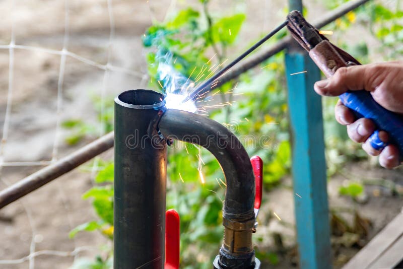 Worker Cooks the Heating Pipe, Welding Joint. Preparing for Winter ...