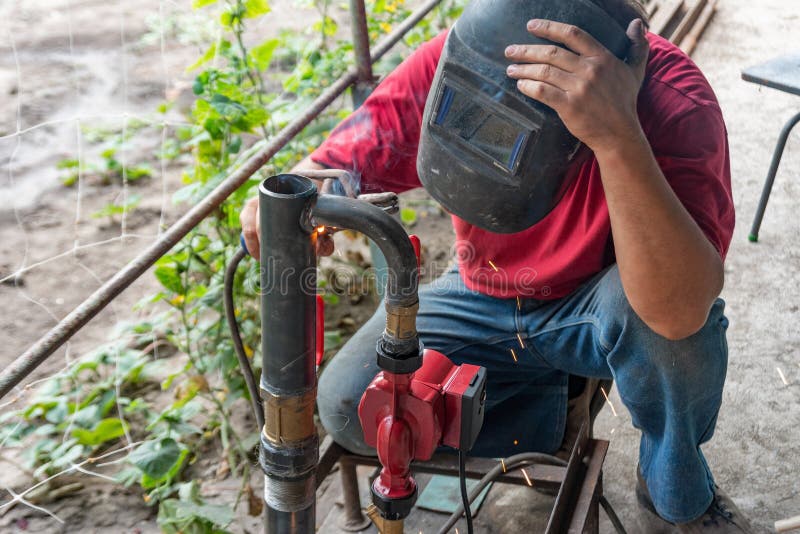 Worker Cooks the Heating Pipe, Welding Joint. Preparing for Winter ...