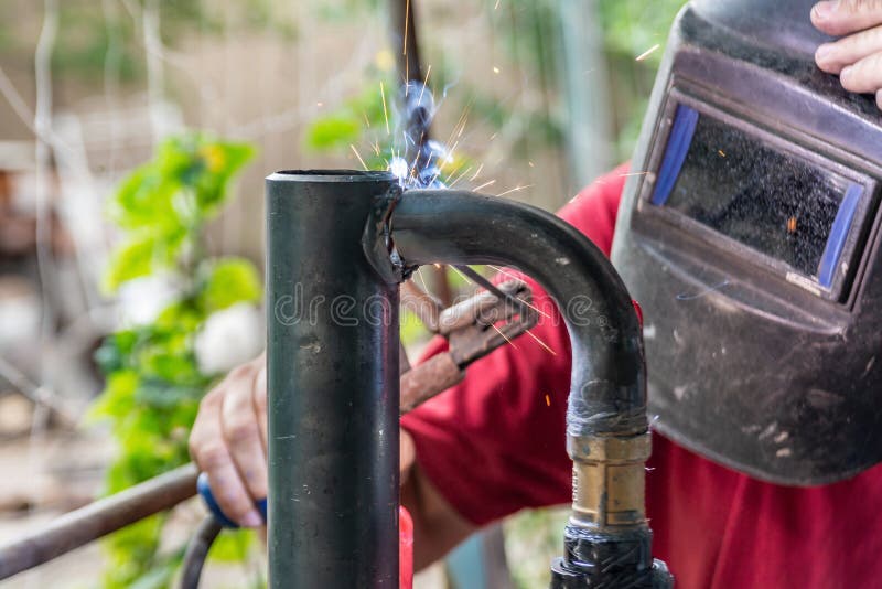 Worker Cooks the Heating Pipe, Welding Joint. Preparing for Winter ...
