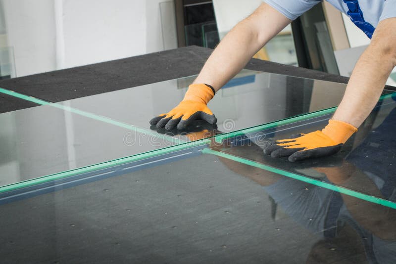 A Worker Cuts and Breaks Glass on a Professional Table in a Workplace ...