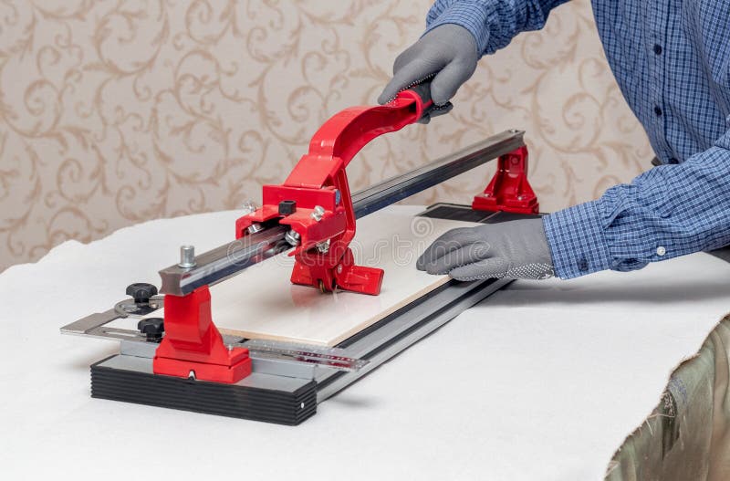A Worker Cuts Facing Tiles with a Tile Cutter Stock Photo - Image of ...