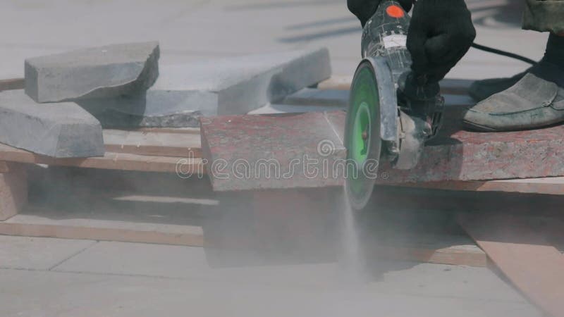A Worker Cuts a Granite Slab with a Grinder. Working Process at a ...