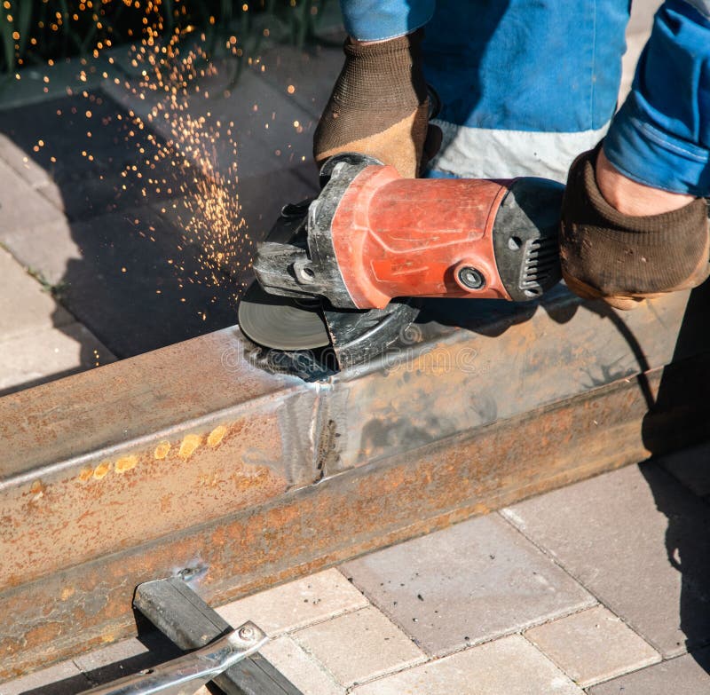 A Worker Cuts Metal at a Construction Site. Stock Image - Image of ...