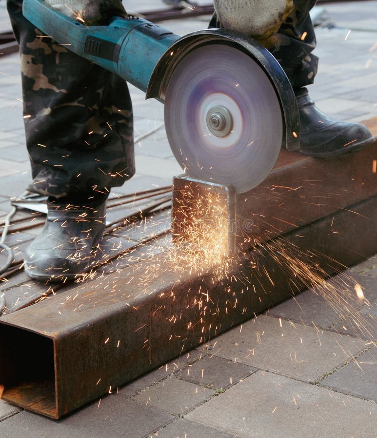 A Worker Cuts Metal at a Construction Site. Stock Image - Image of ...