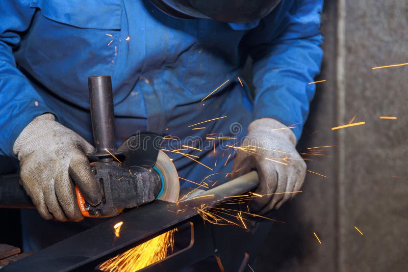A Worker Cuts Metal with an Using Abrasive Disk in an Industrial ...