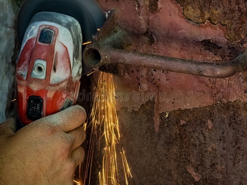 A Worker Cuts an Old Metal Lock with a Grinder. Sparks during Operation ...