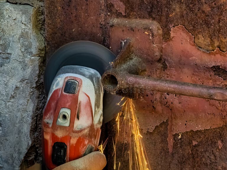 A Worker Cuts an Old Metal Lock with a Grinder. Sparks during Operation ...