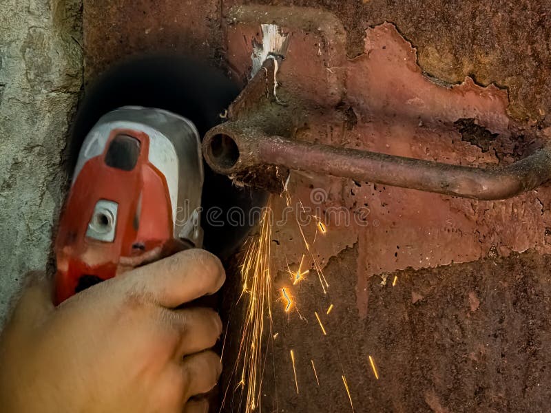 A Worker Cuts an Old Metal Lock with a Grinder. Sparks during Operation ...