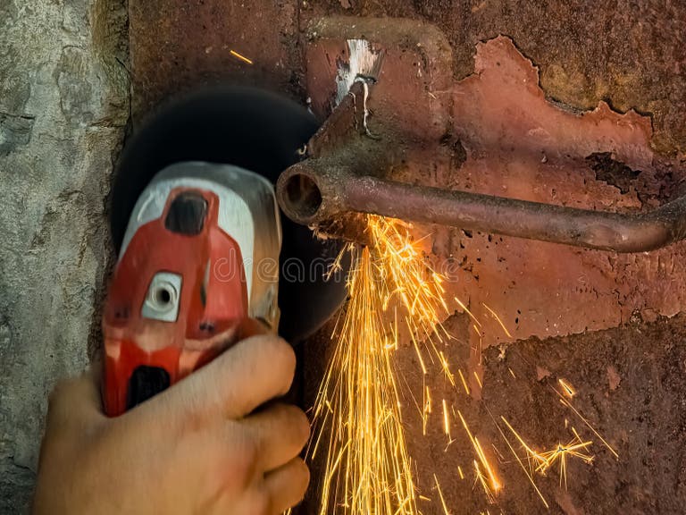 A Worker Cuts an Old Metal Lock with a Grinder. Sparks during Operation ...