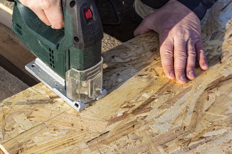 A Worker Cuts an OSB Sheet with a Jigsaw Stock Photo - Image of ...