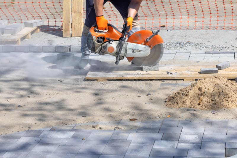A Worker Cuts Paving Slabs at the Workplace with a Disk Power Cutter ...
