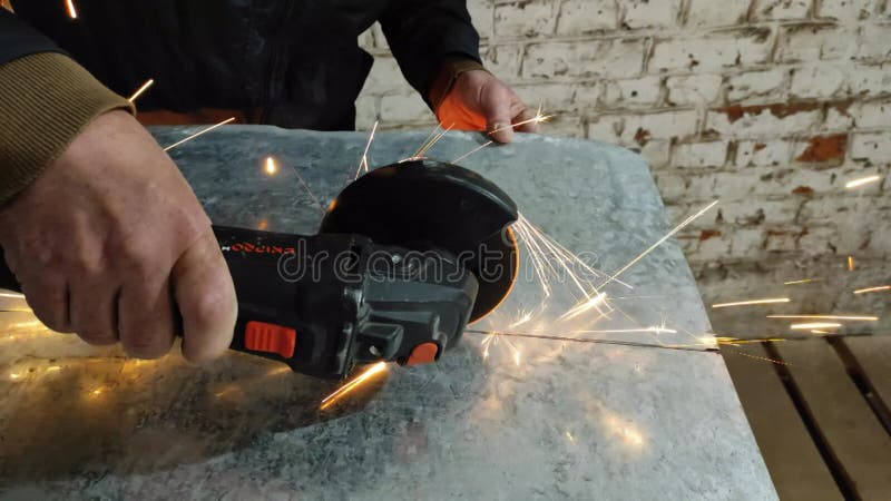 A Worker Cuts a Sheet of Iron with a Grinder. Cutting Metal with an ...