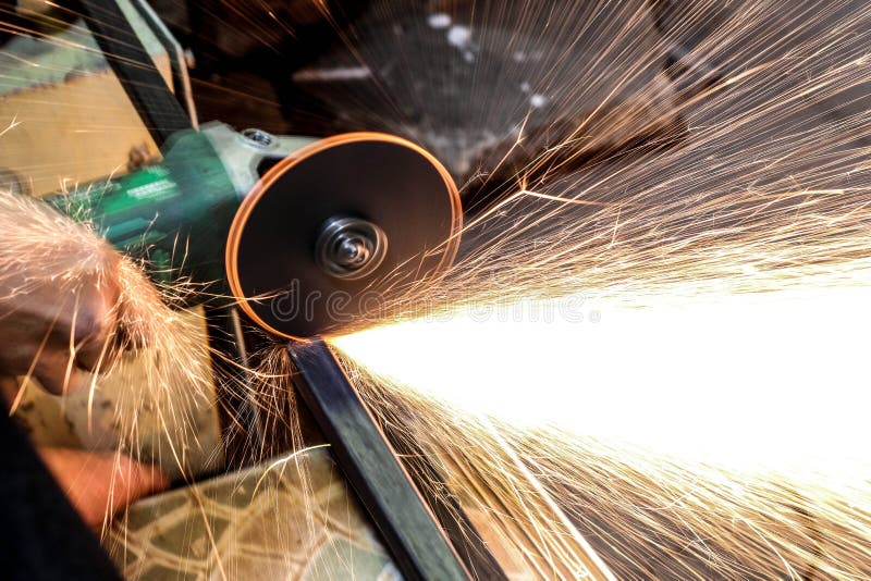 Worker Cutting Metal with Grinder. Sparks while Grinding Iron Stock ...