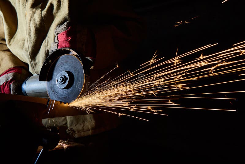 Worker Cutting Metal with Grinder. Sparks while Grinding Iron Stock ...