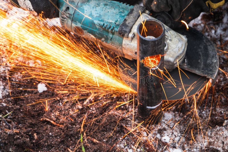Worker Cutting Metal Pipe with Angle Grinder, Creating Sparks Outdoors ...
