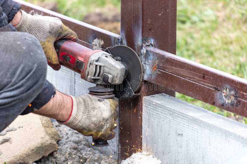 A Worker is Cutting Metal To Install a Fence Stock Image - Image of ...