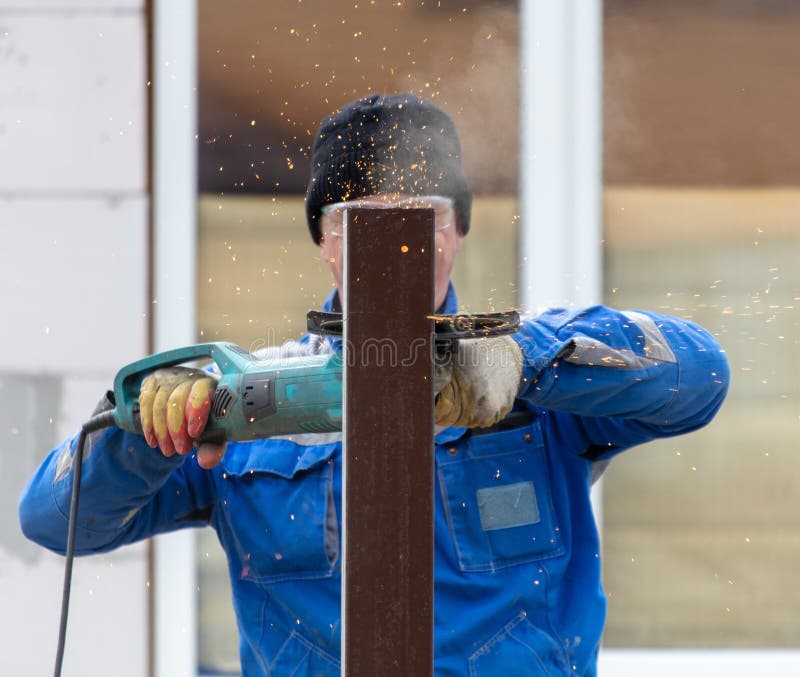 A Worker is Cutting Metal To Install a Fence Stock Photo - Image of ...