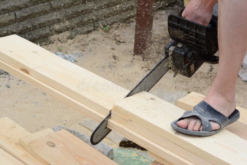 Worker Cutting Stack of Wood Planks with Electric Saw. Cut Wood Timber ...