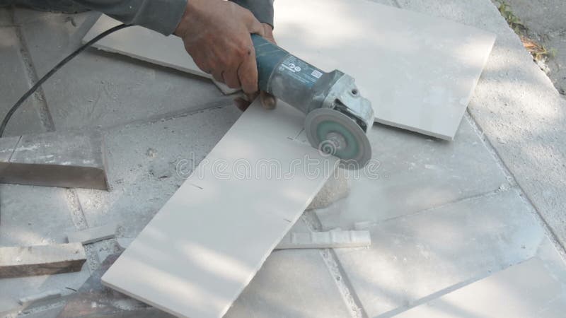 Worker Cutting a Tile Using an Angle Grinder at Construction Site Stock ...