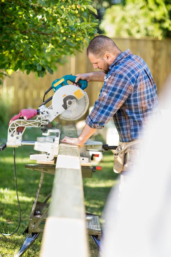 Worker Cutting Wood with Saw while Coworker Stock Photo - Image of ...