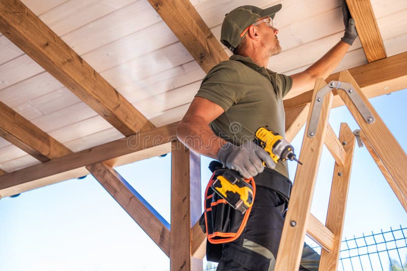 Skilled Worker Installing Ceiling Paneling while Standing on Ladder in ...
