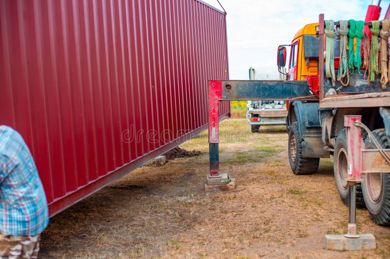 A Worker Directs a Cargo Container Being Lowered into Place at Its ...