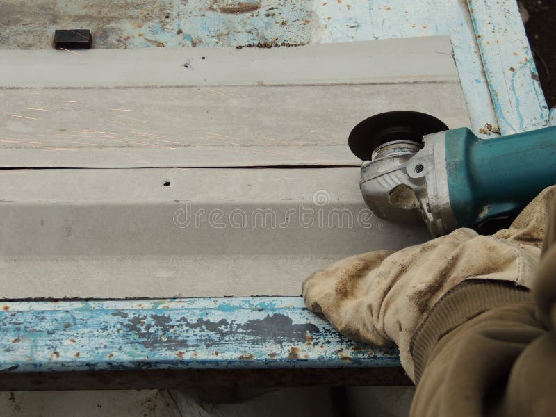 A Worker Cuts a Metal Sheet with a Grinder Stock Photo - Image of ...