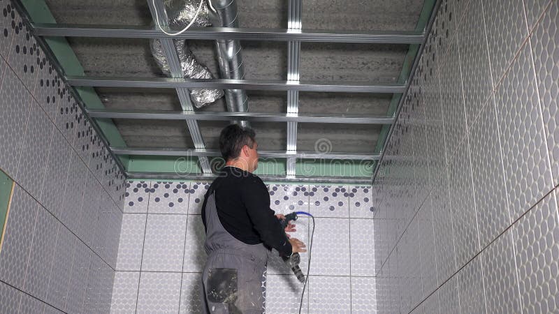 Worker Drill Hole and Fix Ceiling Profiles with Cordless Drill ...