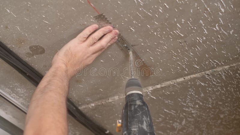 Worker Drills a Hole in the Ceiling with a Hammer Drill To Install the ...