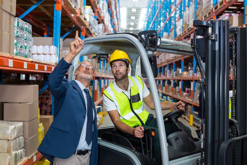 Worker Driving Forklift Discussing with Businessman Stock Photo - Image ...