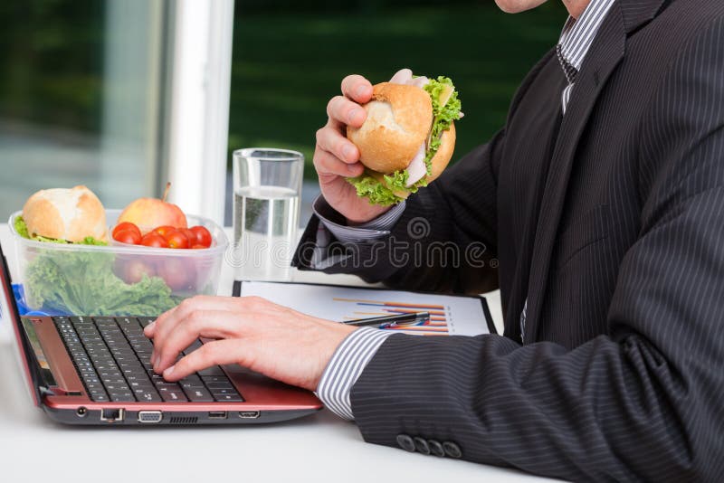 Worker eating at his desk stock photo. Image of office - 38975278