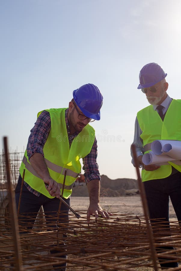 Worker and Engineer at Building Site Stock Photo - Image of grid ...