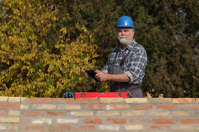 Worker Examining Brick Wall, Using Tablet Stock Photo - Image of ...