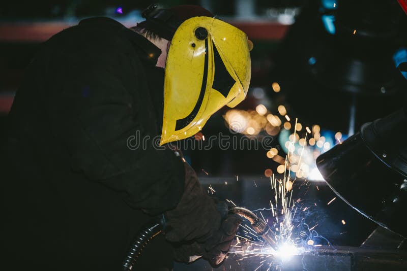 Worker at the Factory in the Helmet is of Iron in the Welding Pr Stock ...
